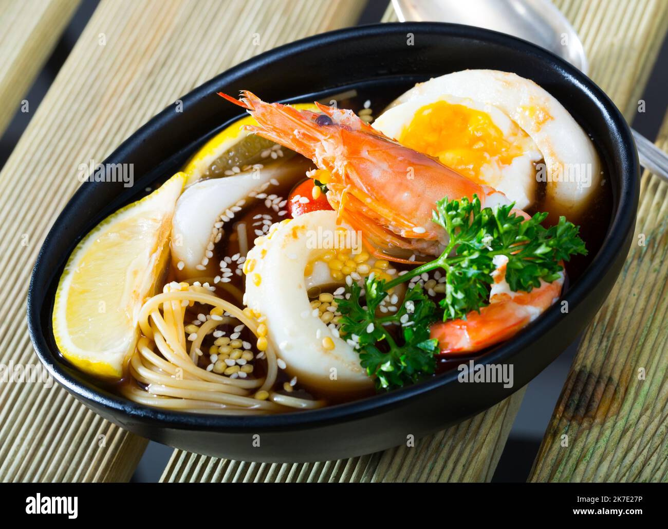 Spicy pan-Asian soup boiled with squid, shrimp, egg noodles Stock Photo ...