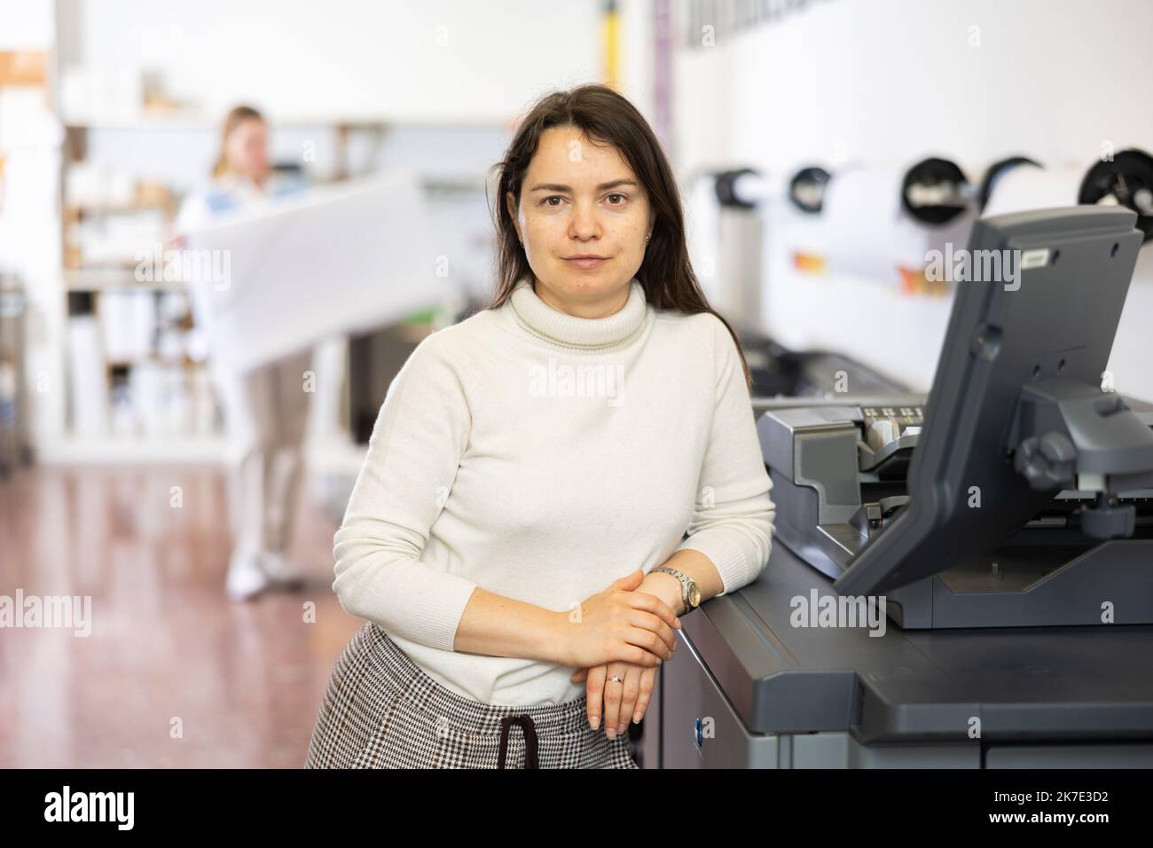 Technician operator calibrating plotter machine, typing on computer ...