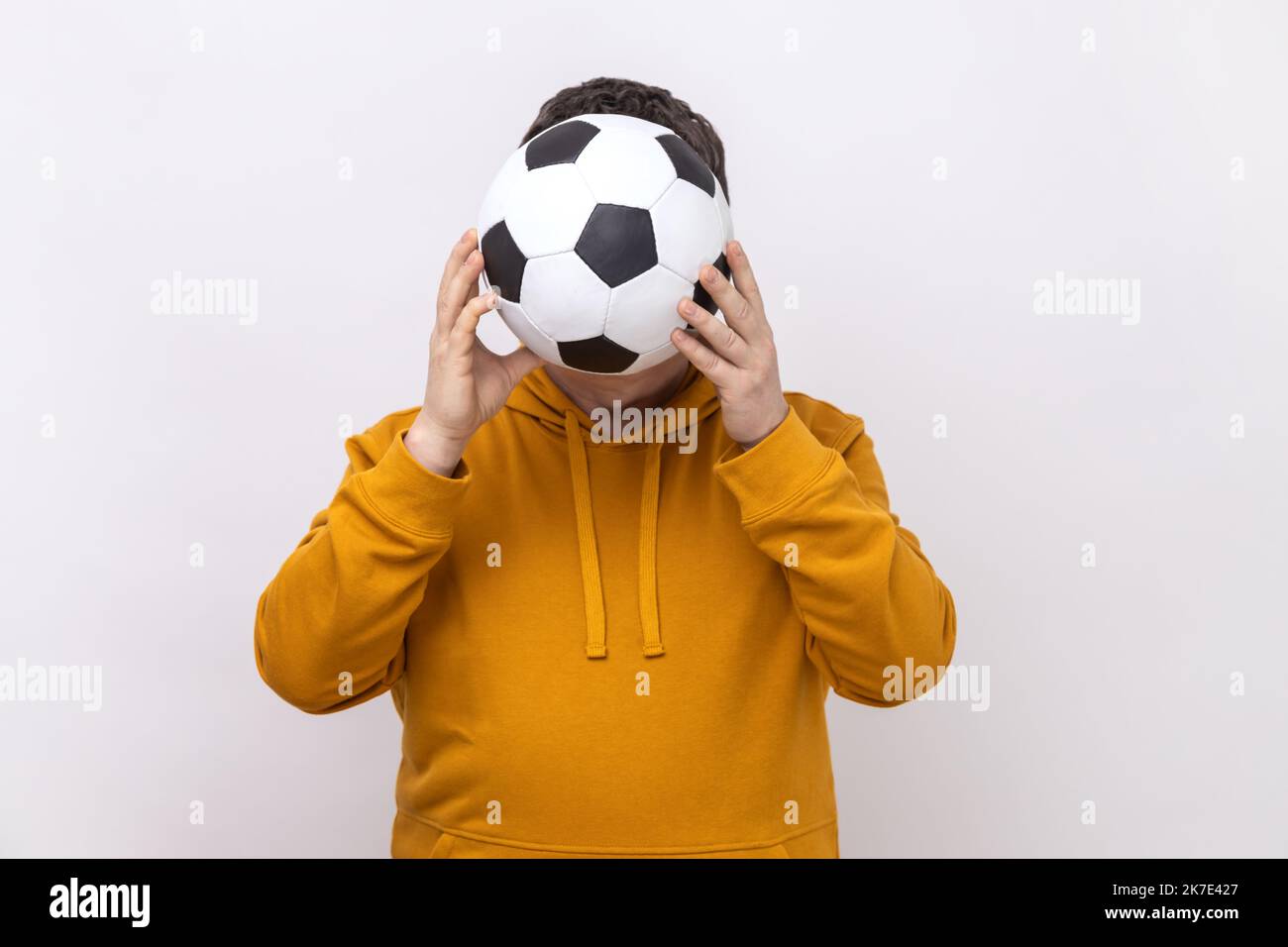 Anonymous unknown man hiding behind soccer ball, football fan covering ...