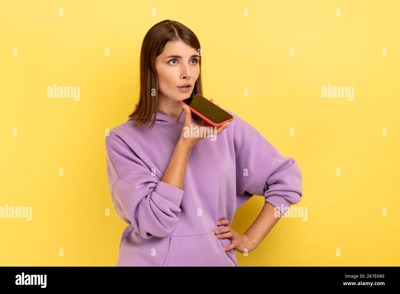 Portrait of woman talking to smartphone using digital voice app ...