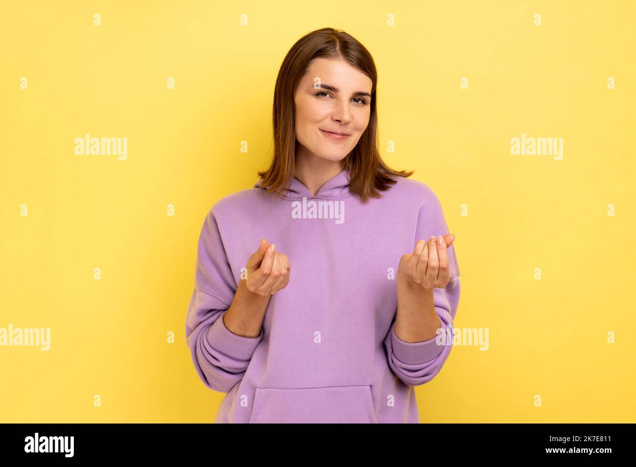 Attractive smiling young adult woman standing and looking at camera ...