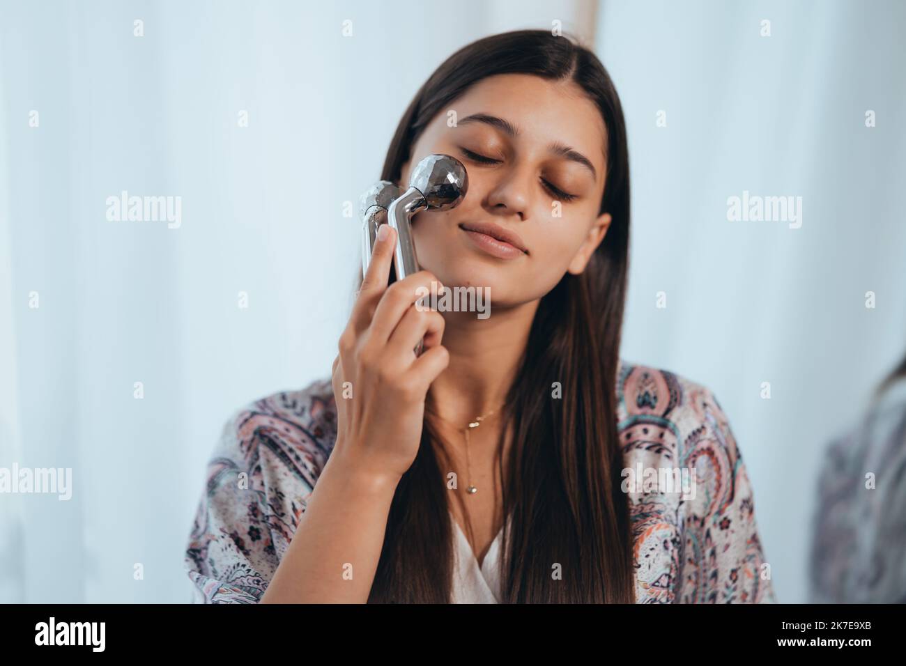 Woman massaging her cheek with massage Y-shaped ball roller Stock Photo ...