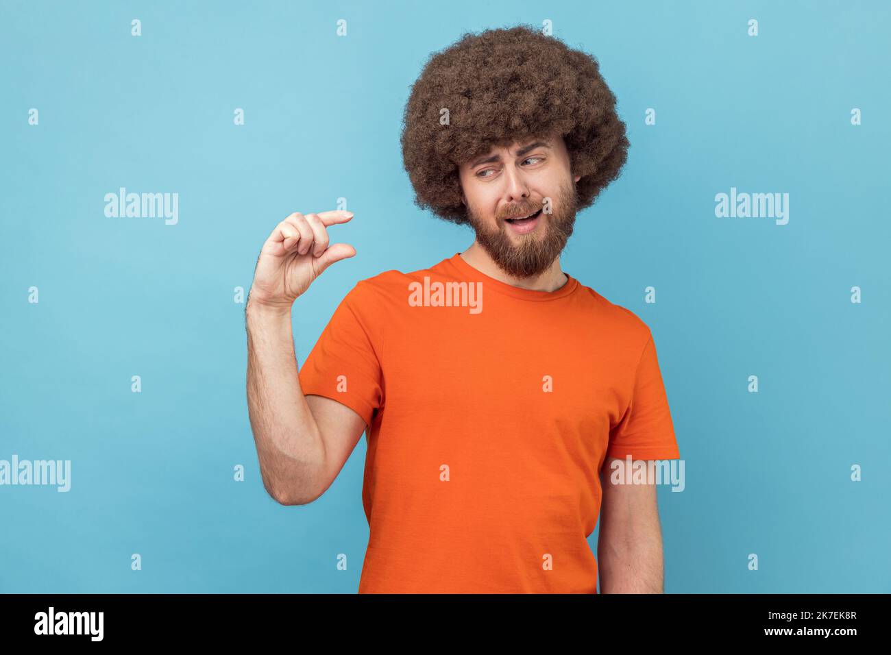 Not very much. Portrait of man with Afro hairstyle wearing orange T ...