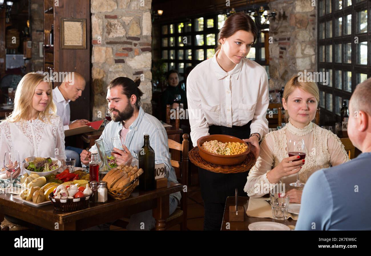 Young female waiter serving country restaurant guests Stock Photo - Alamy