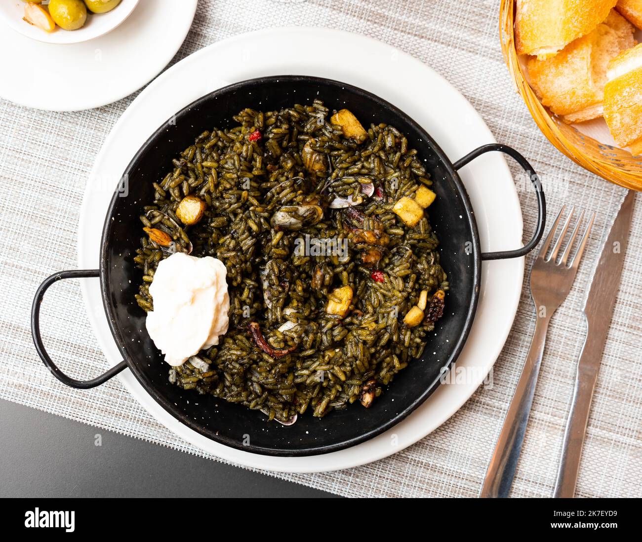 Traditional Valencian paella Arroz negro with squid ink served with ...