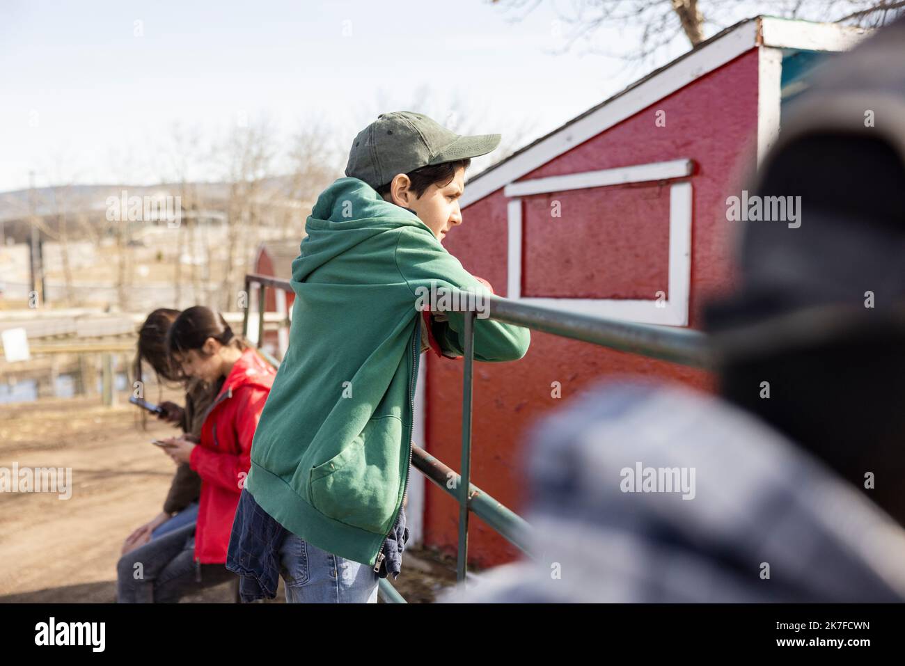 Boy leaning on fence at sunny farm Stock Photo - Alamy