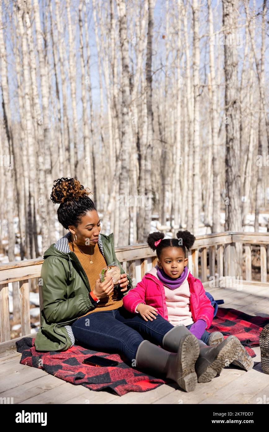 Mother and daughter eating sandwich on sunny tractor ride Stock Photo ...