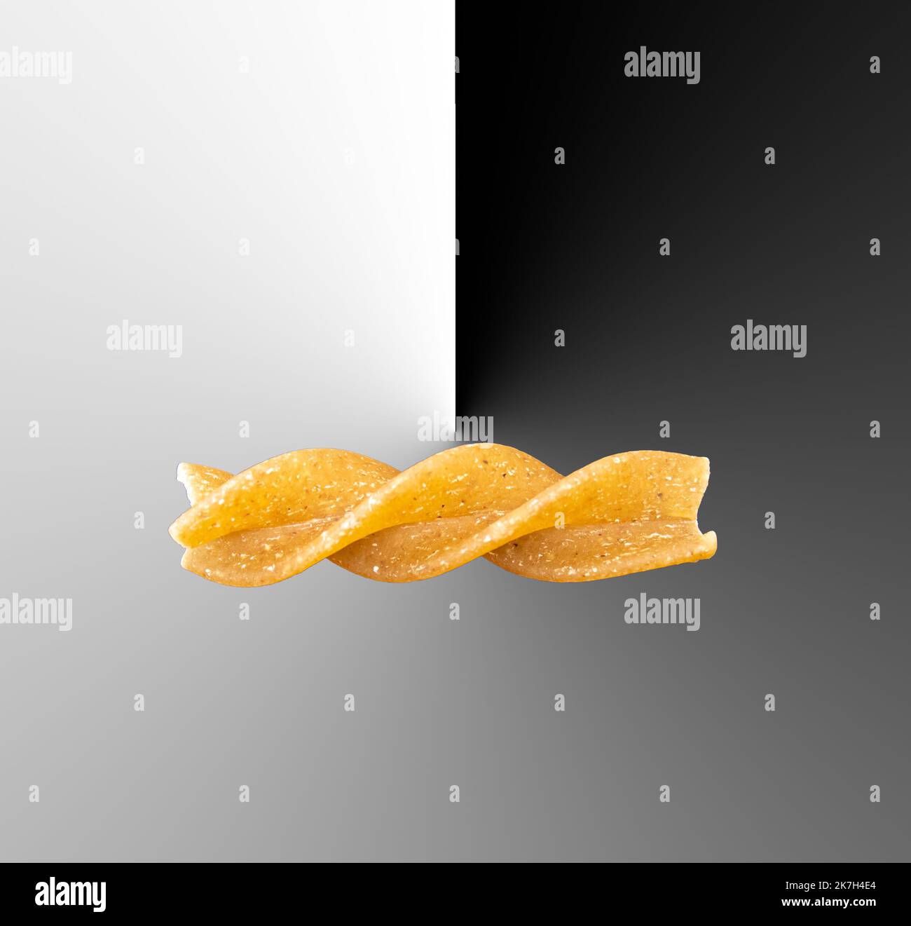 A single piece of fusilli pasta in a composite picture with a black and ...