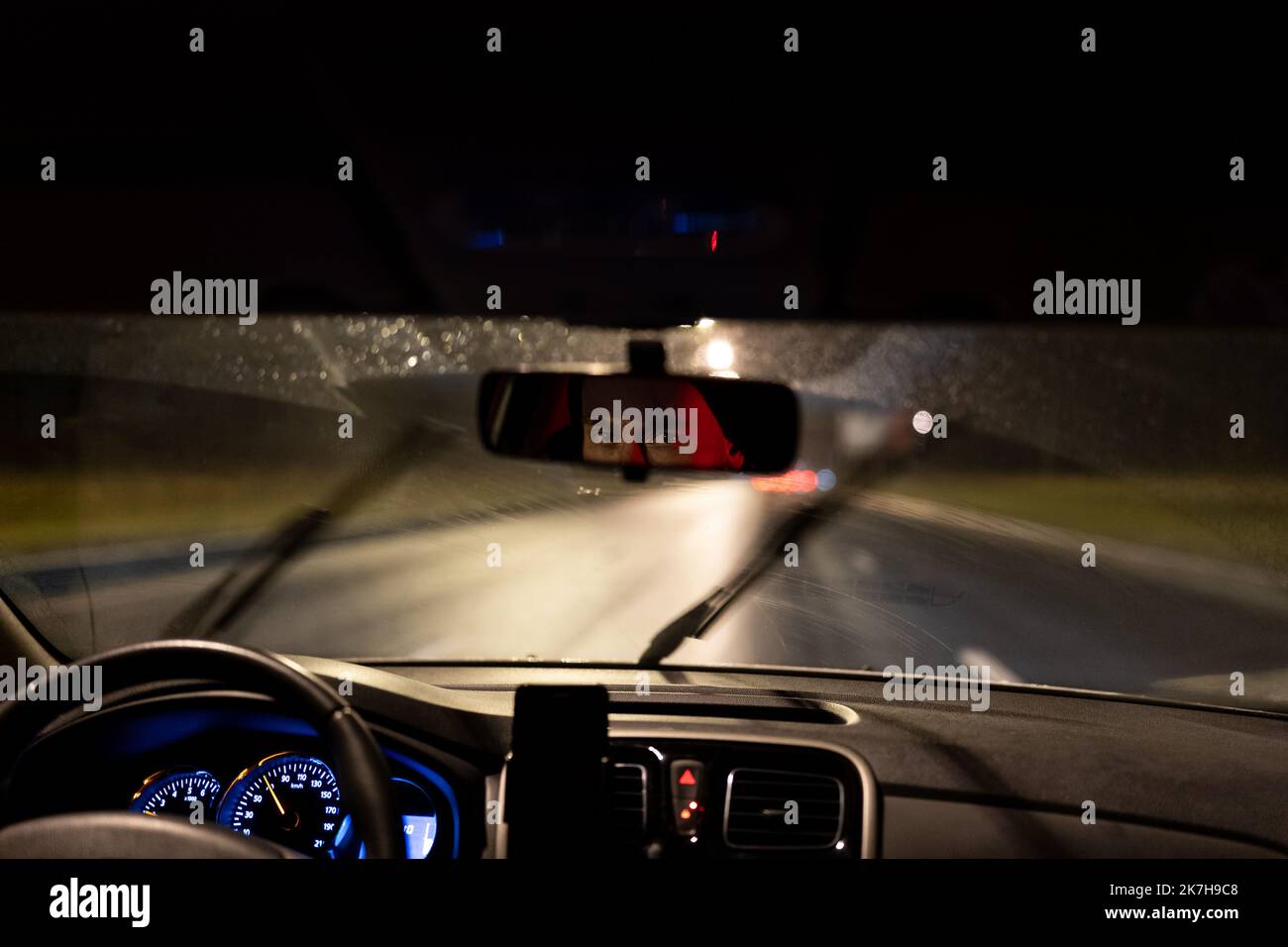 Eyes of young man taxi driver are reflected in rearview mirror during ...