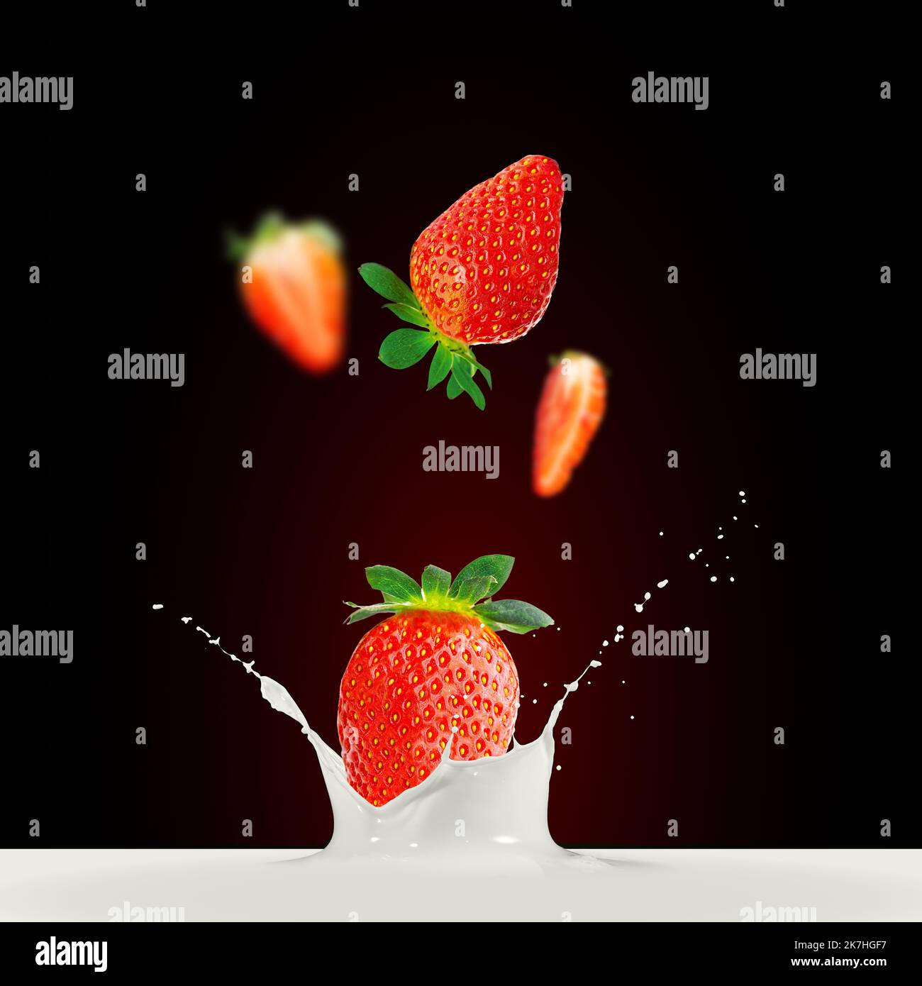 Strawberry falling into milk splash on dark background Stock Photo - Alamy