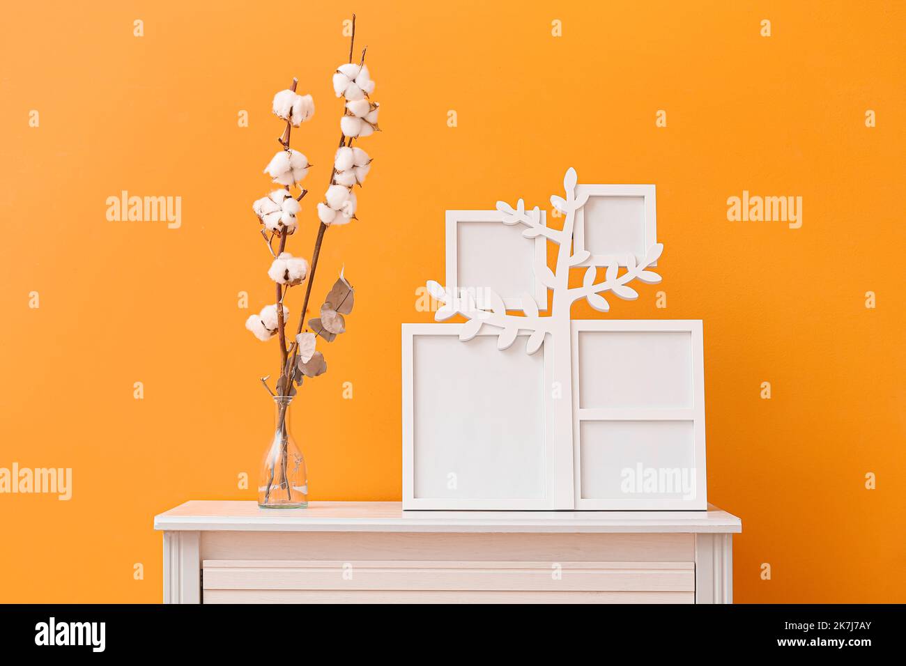Family tree with photo frames, vase and cotton flowers on shelf near ...