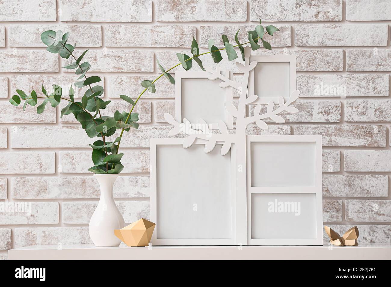 Family tree with photo frames, eucalyptus branches in vase and decor on ...