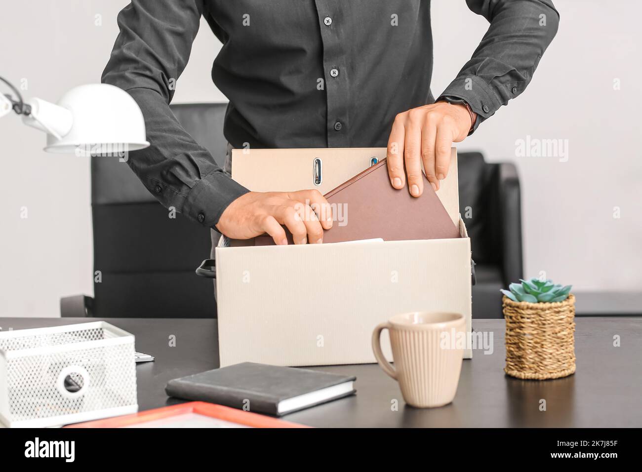 Fired young man packing his stuff in office, closeup Stock Photo - Alamy