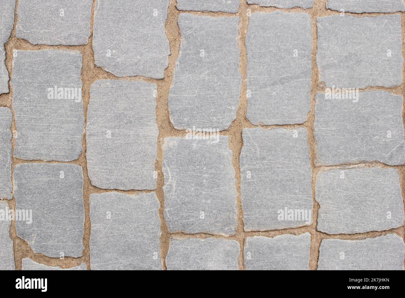 Texture of fragment of gray path made of masonry with sand in seams ...