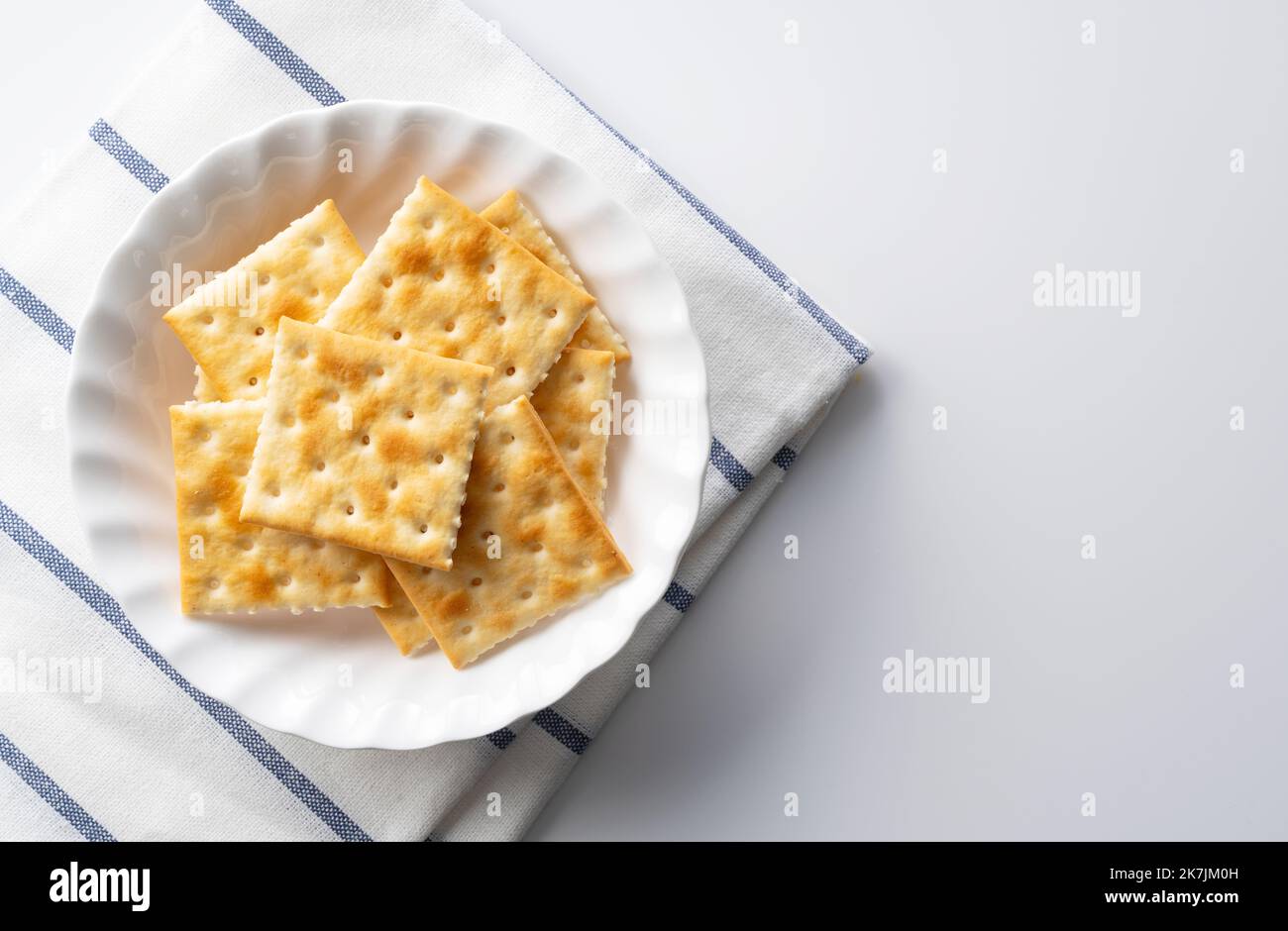 Lots of crackers in a plate placed on a white background with space ...