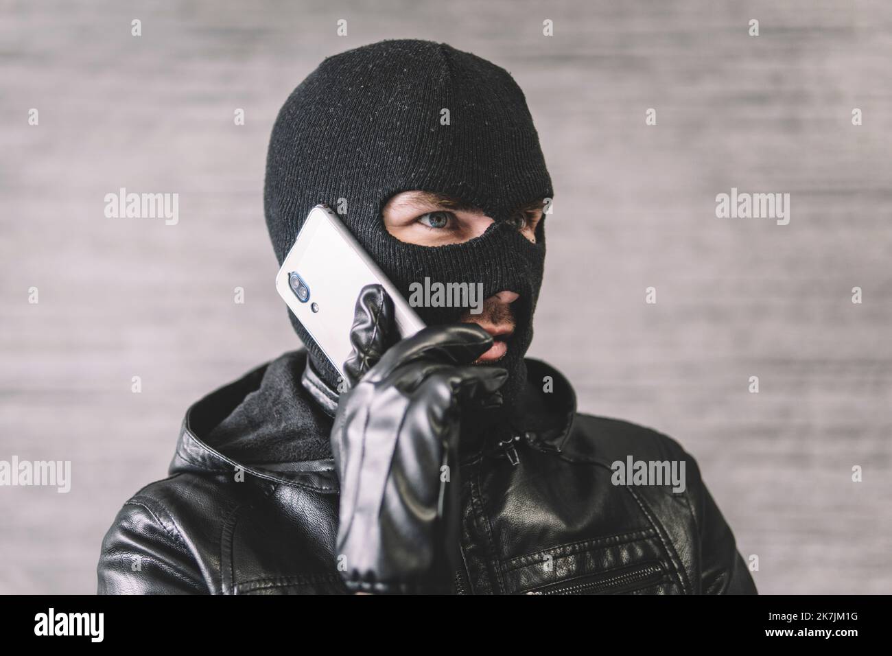 The thief is talking on the phone in a black mask. The extortionist ...