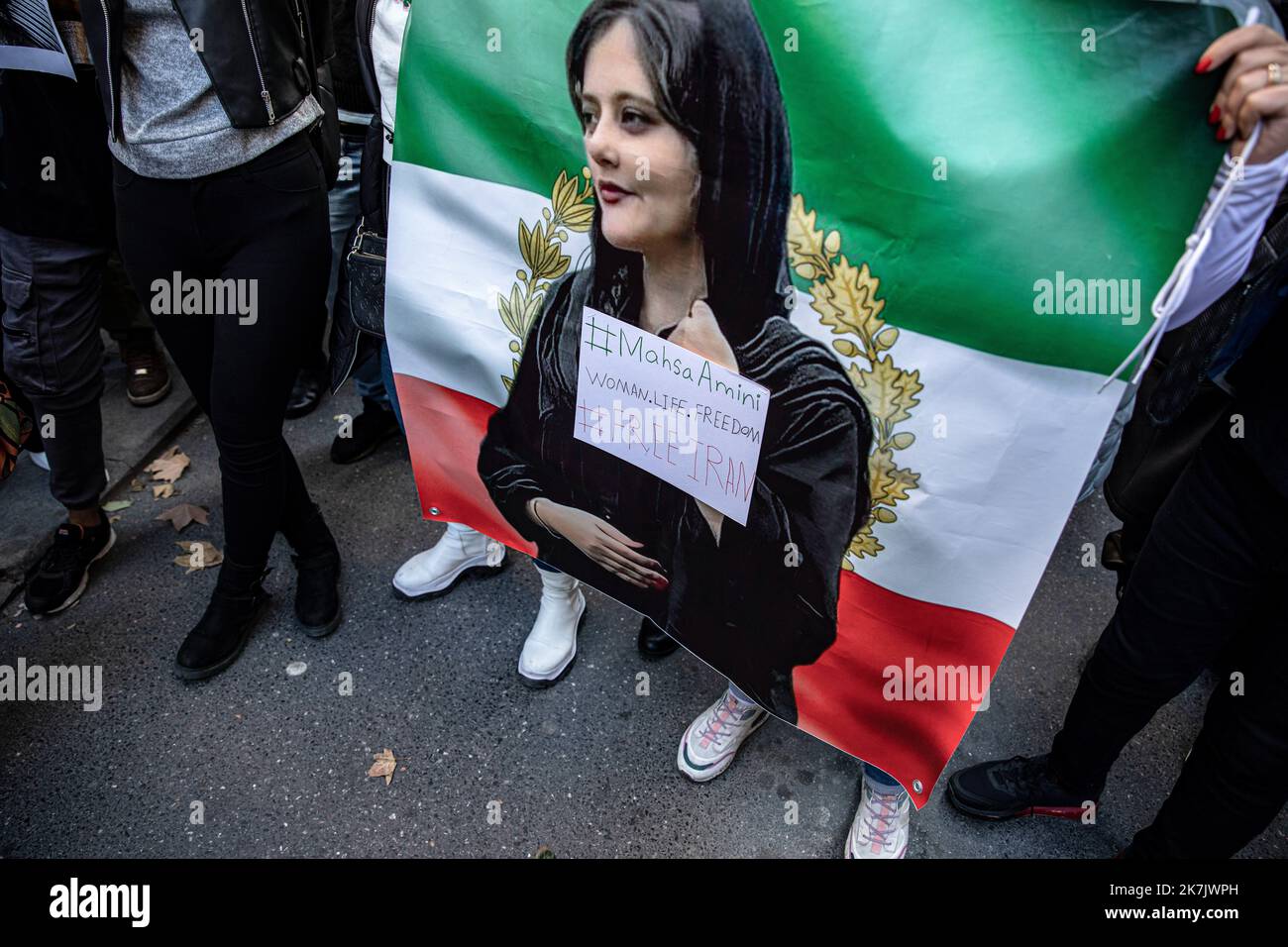 A protester holds a banner with a picture of Mahsa Amini during a ...