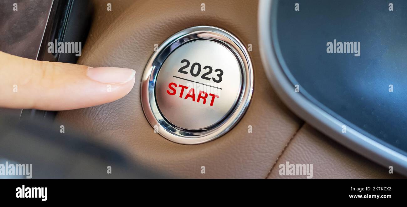 Finger press a car ignition button with 2023 START text inside ...