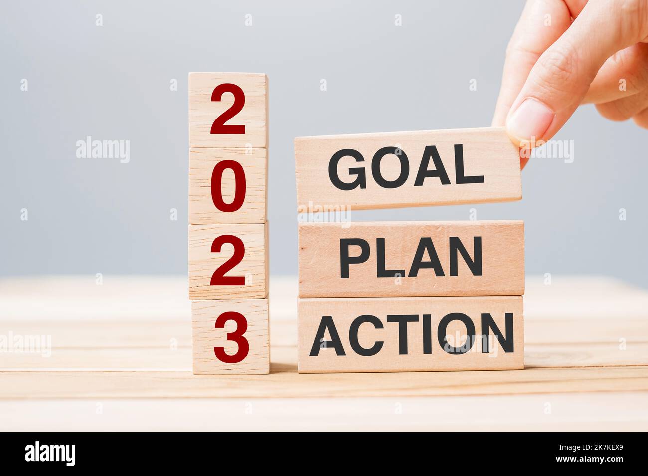 hand holding wooden block with text 2023 GOAL, PLAN and ACTION on table background. Resolution ...
