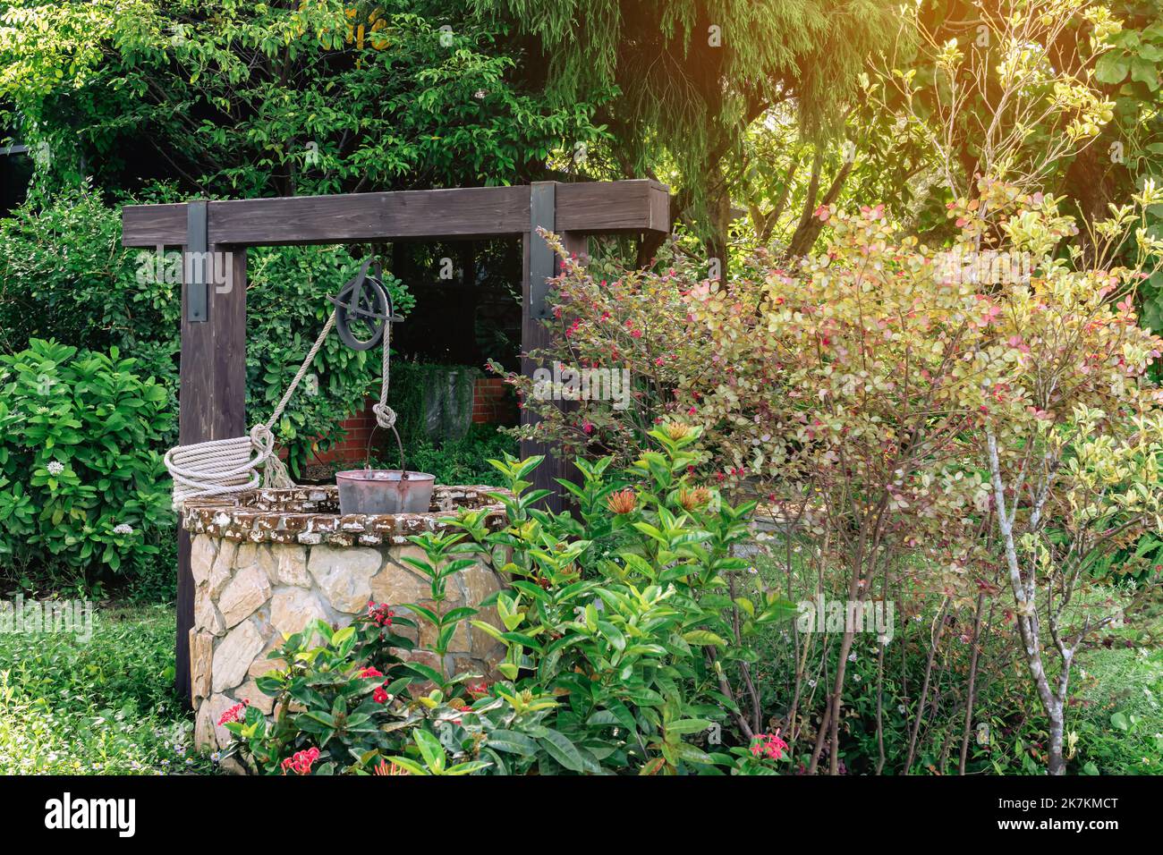 Beautiful artesian well made by stones and wheel pulley with metal ...