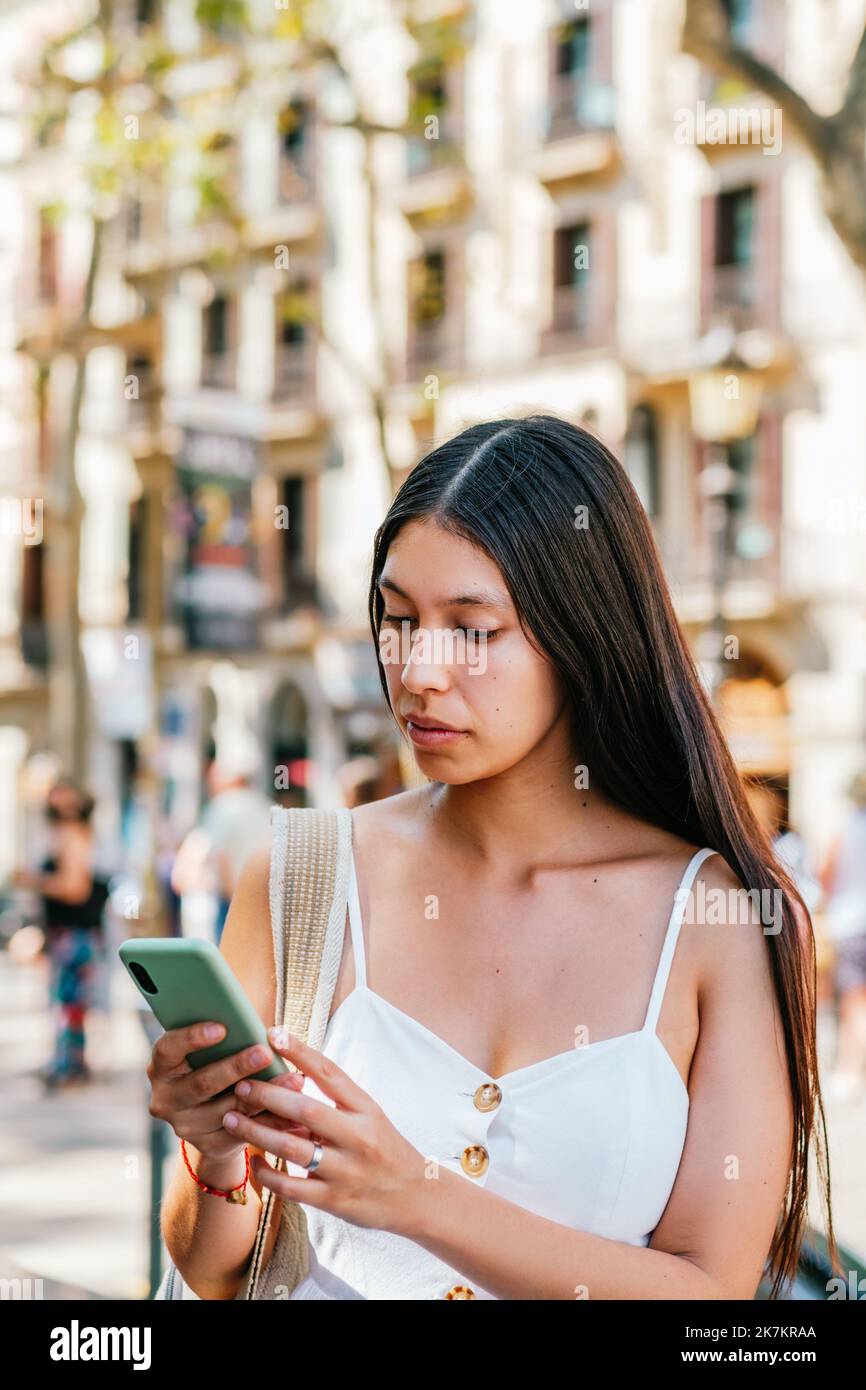 Latin American female scrolling news on social media on smartphone ...