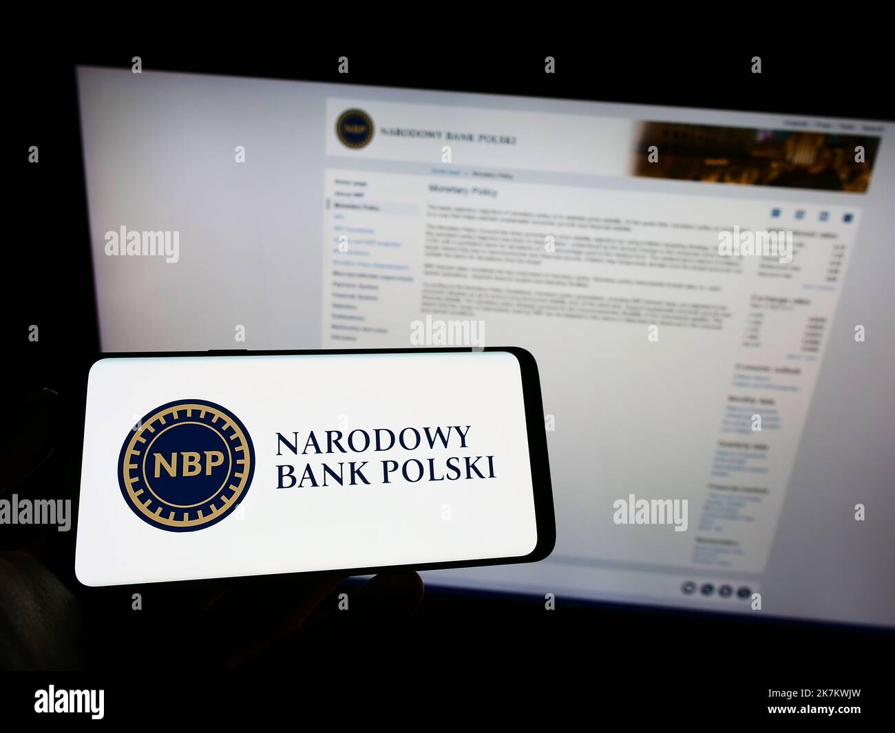 Person holding mobile phone with logo of Polish central bank Narodowy ...