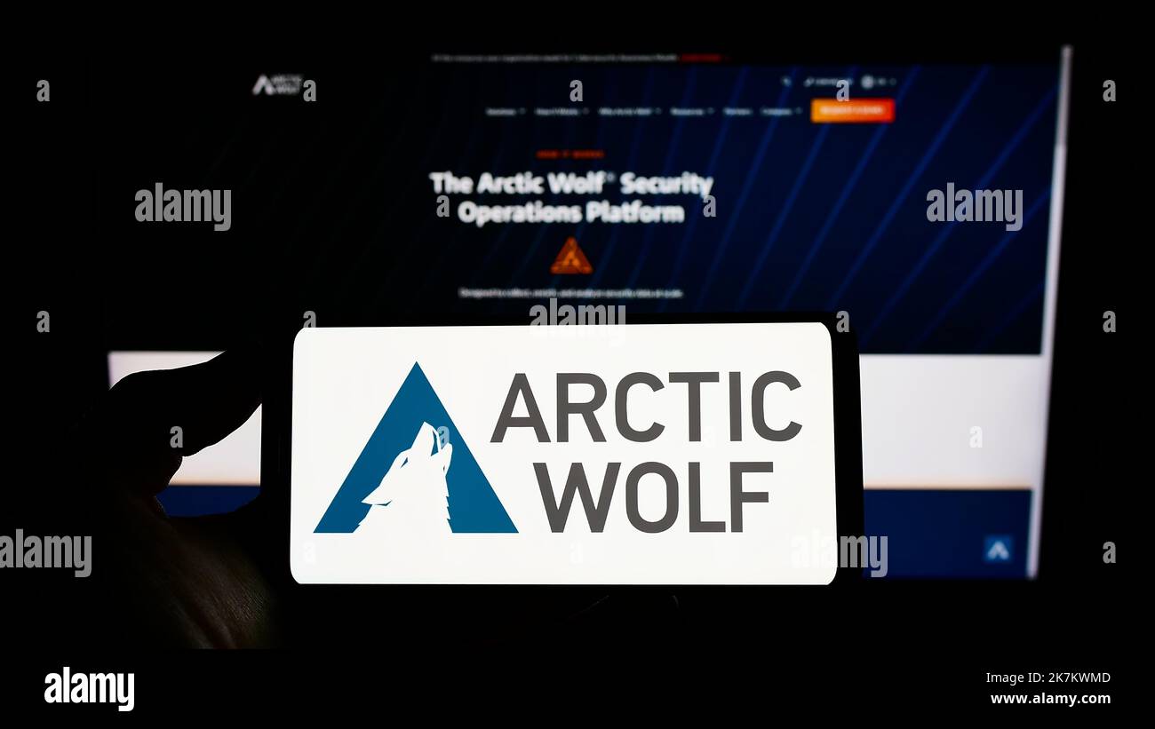 Person holding smartphone with logo of cybersecurity company Arctic ...