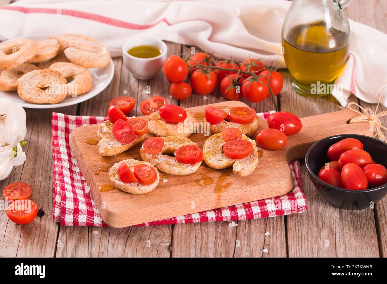 Friselle with cherry tomatoes and olive oil Stock Photo - Alamy
