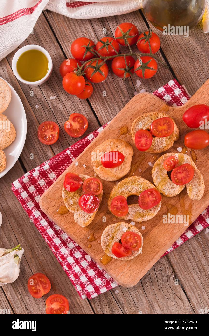 Friselle with cherry tomatoes and olive oil Stock Photo - Alamy