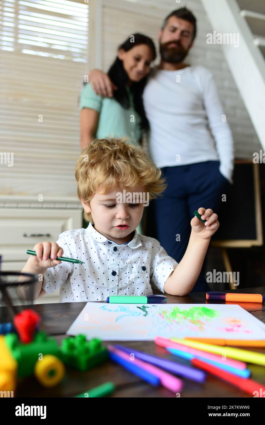 Happy family having fun, parents and little child painting writing in ...