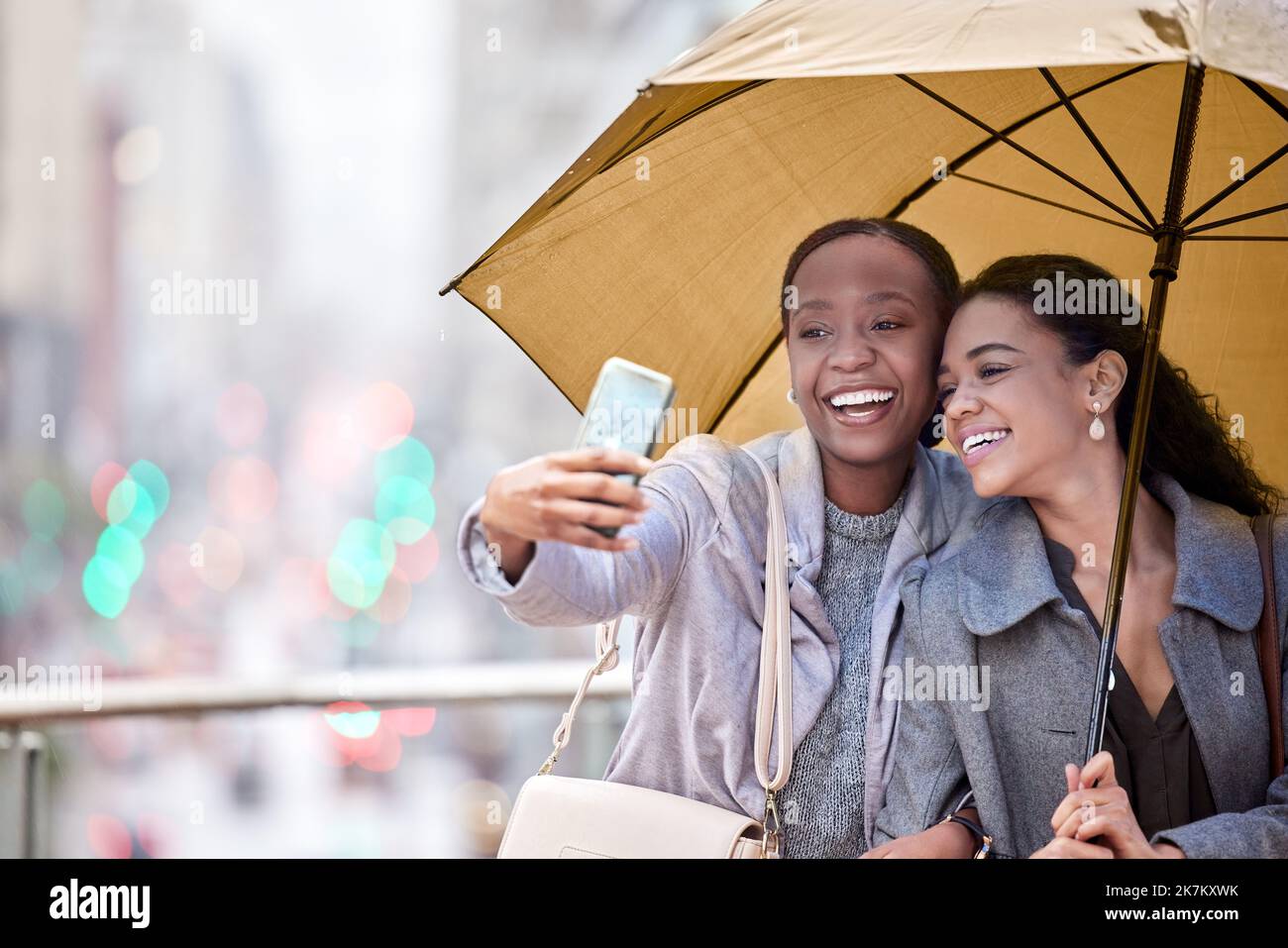 Embracing the cold. two young friends taking a selfie in the rain Stock ...