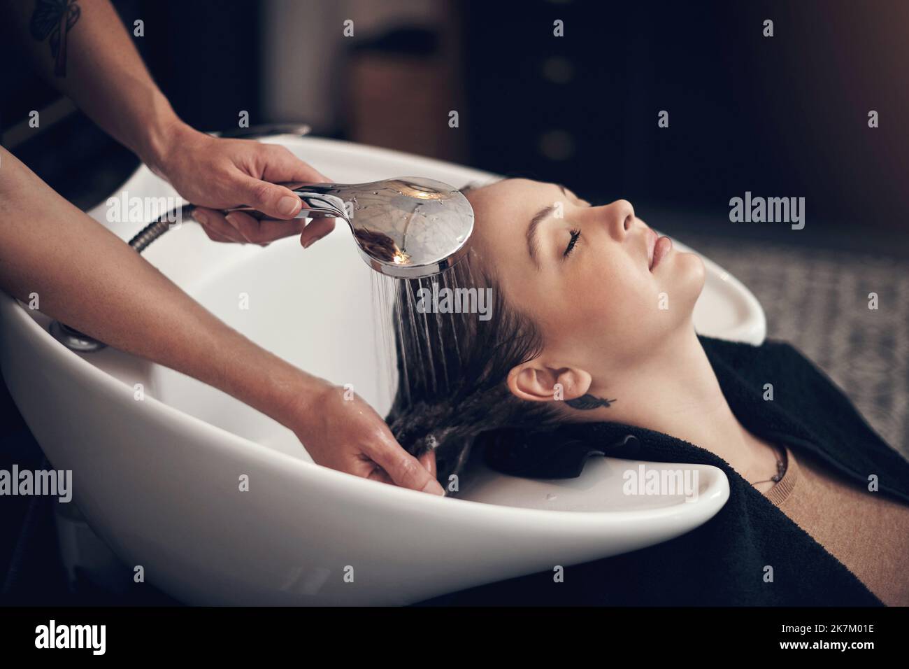 Lets give it a good rinse. a beautiful young woman getting her hair ...