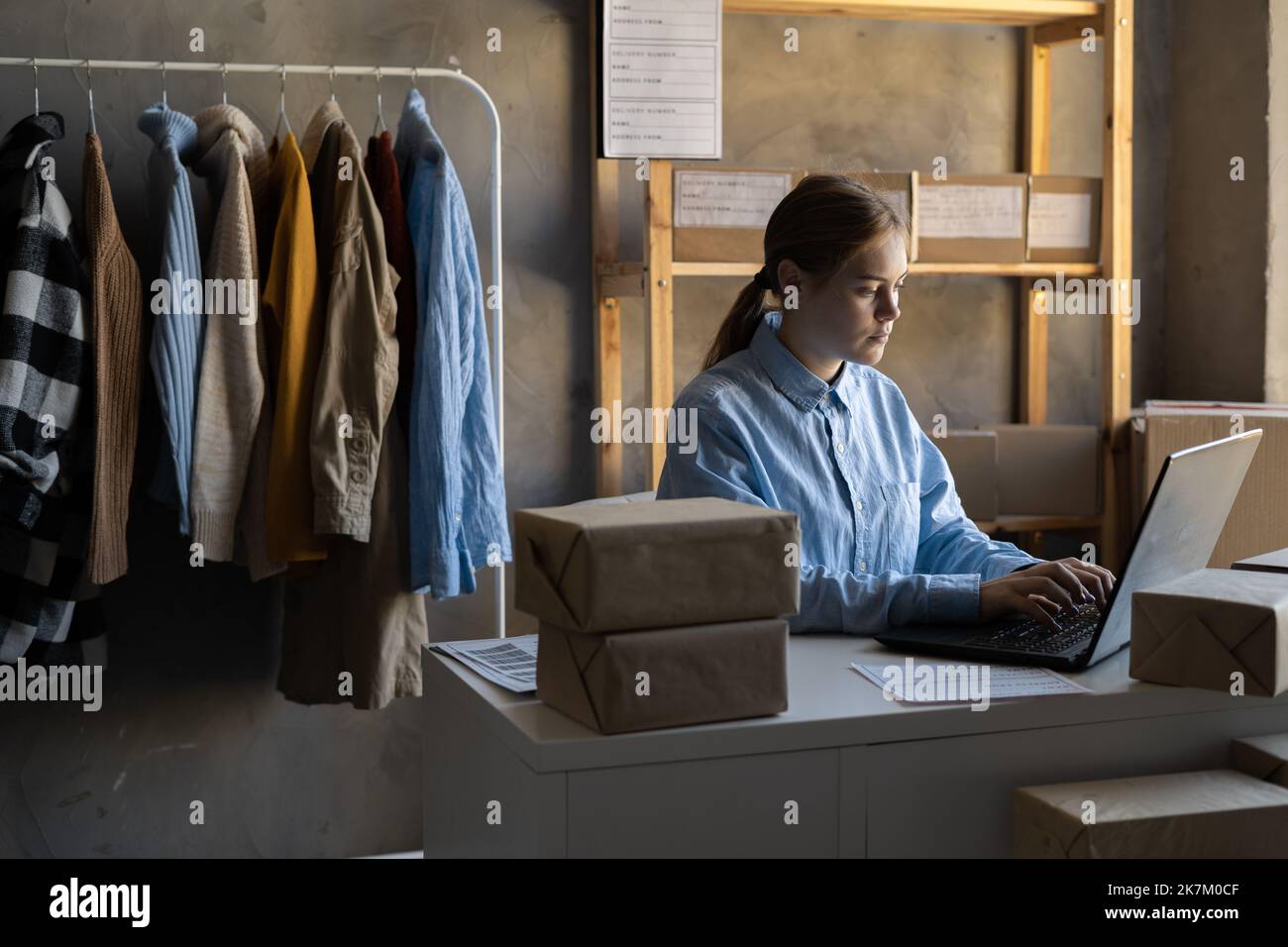 Seller with laptop and parcels in office. Online store, shopping for ...