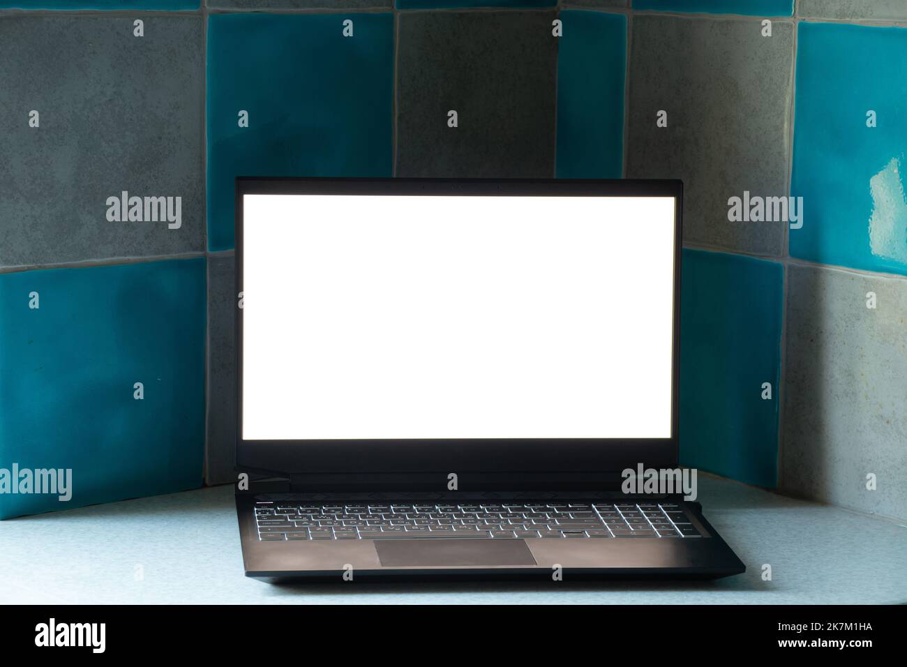 black laptop with white screen stands on the kitchen on the table at ...