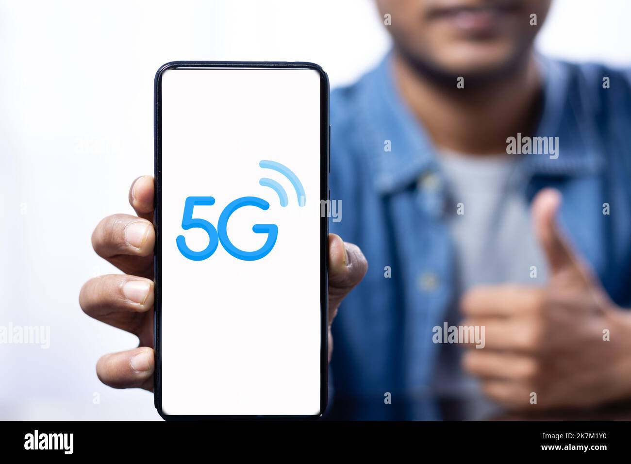 Close up of a smart phone showing 5G network held in hand by a male ...