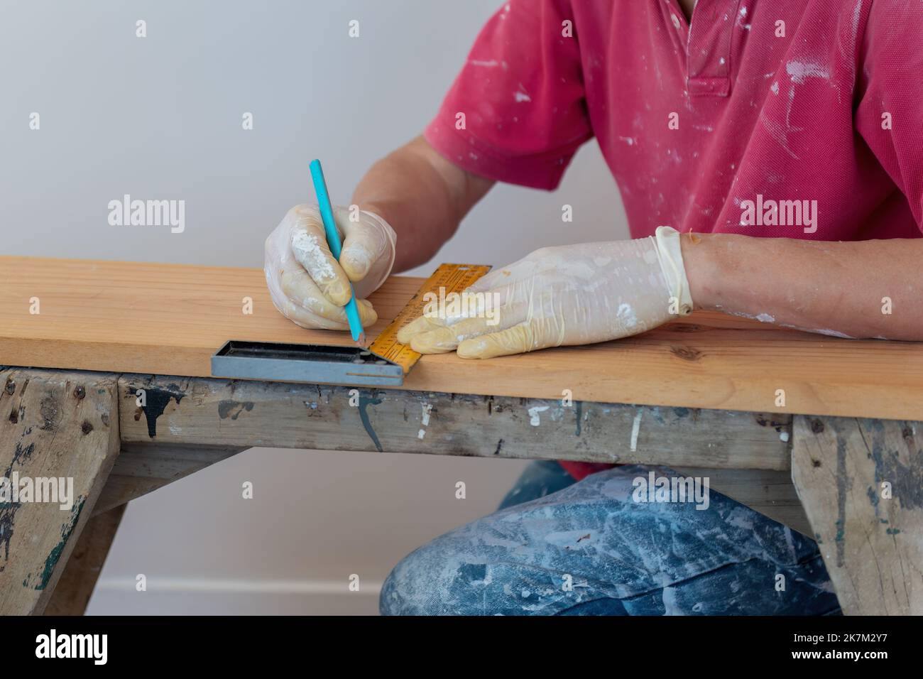 Man marking the line on wood with pencil, selective focus on pencil ...
