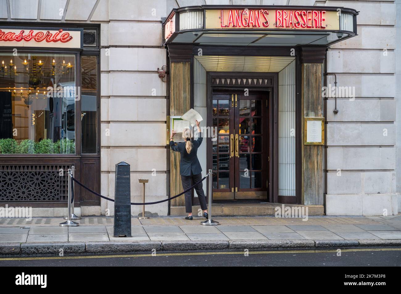 Young woman changing the outside menu display case at Langan's ...