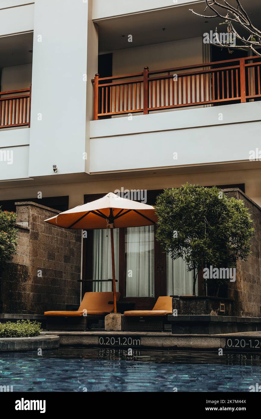 Cozy summer veranda with a sunbed and an umbrella near the pool Stock ...