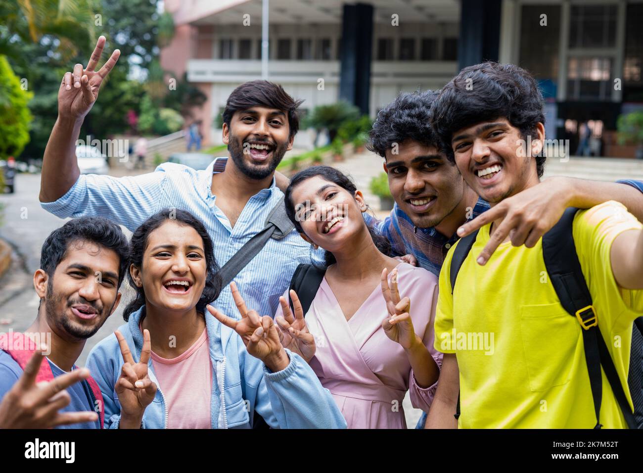 Group of smiling college students taking selfie by holding camera at college campus - concept of ...