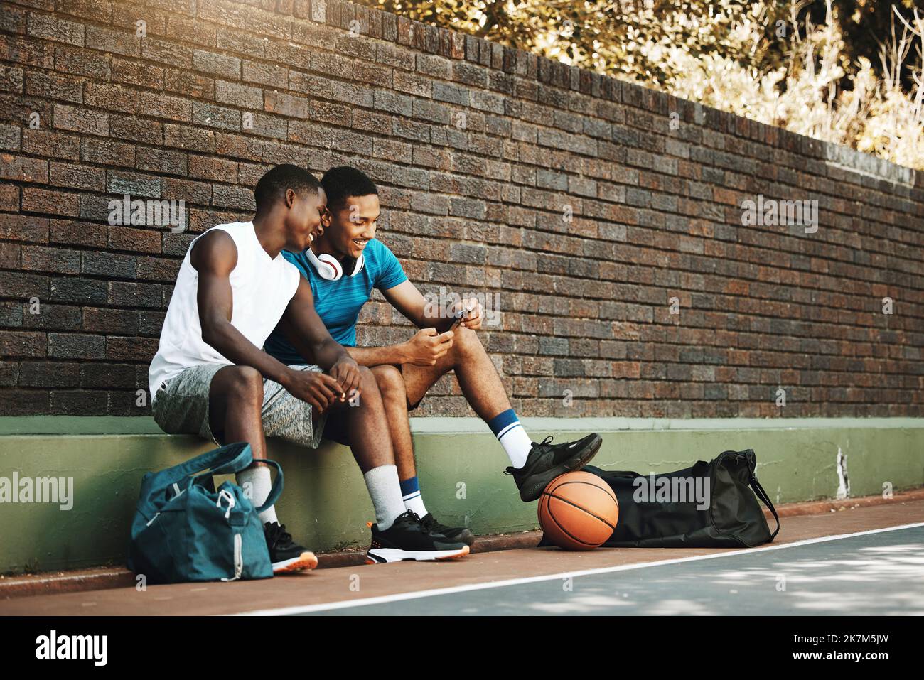 Friends, phone and break after exercise, workout and basketball game in ...