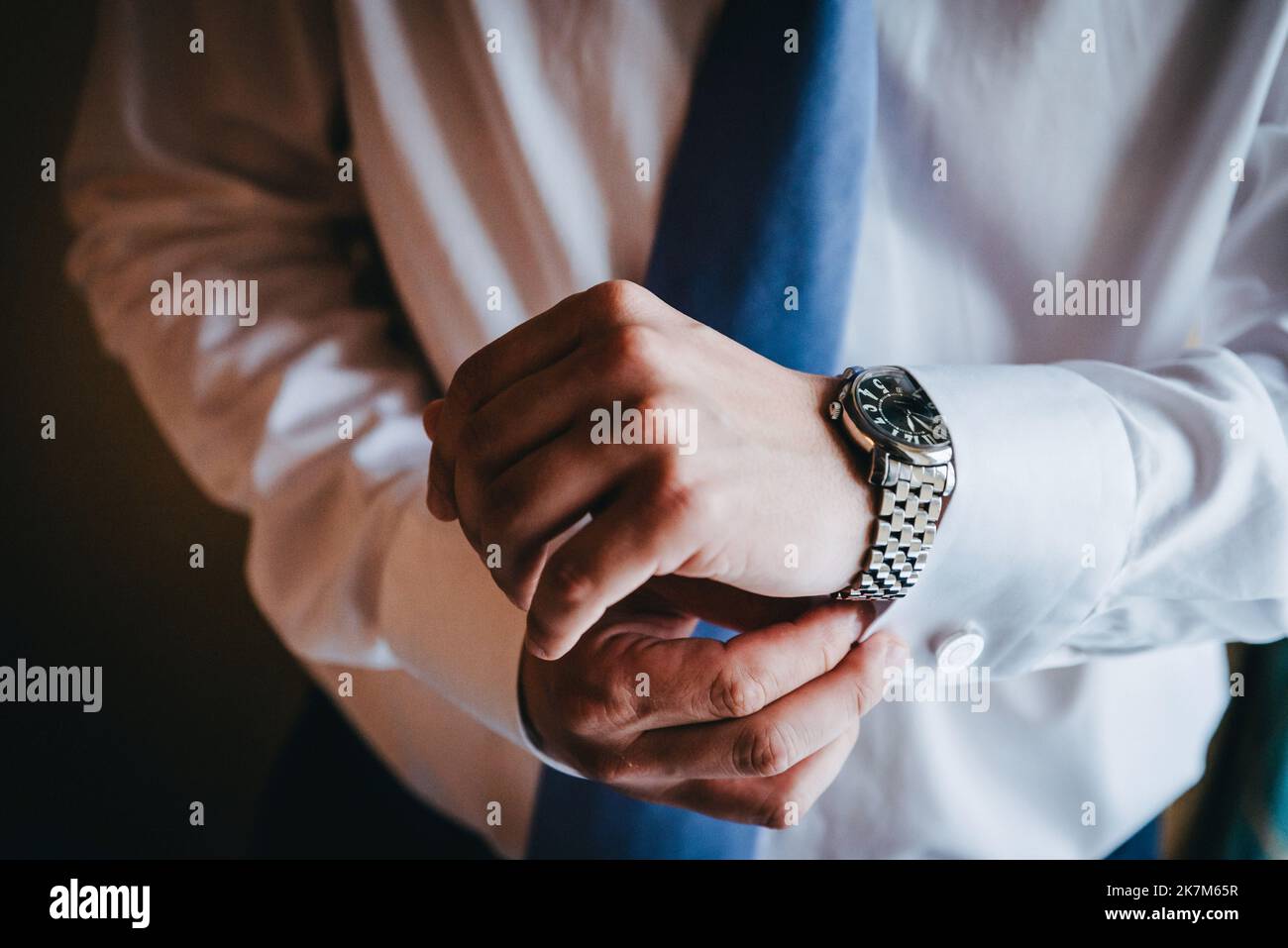 businessman checking time on his wrist watch, man putting clock on hand ...