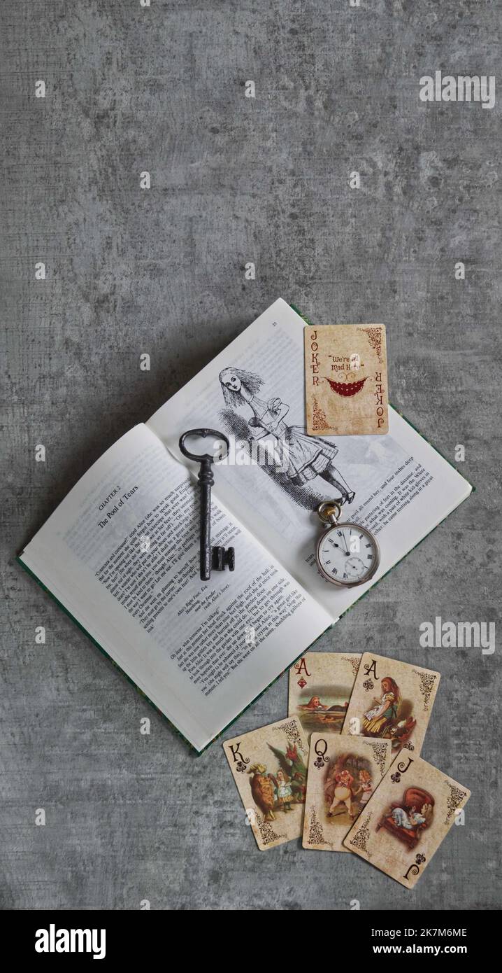 Alice in wonderland book, old key a pocket watch and Playing cards ...