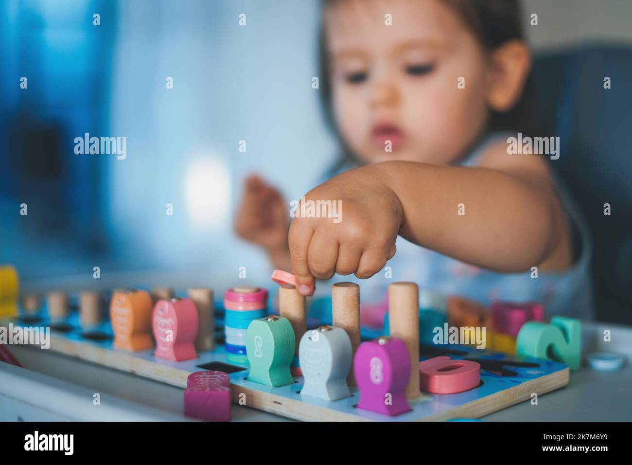 Happy cute Caucasian baby girl sitting on high chair and playing with ...
