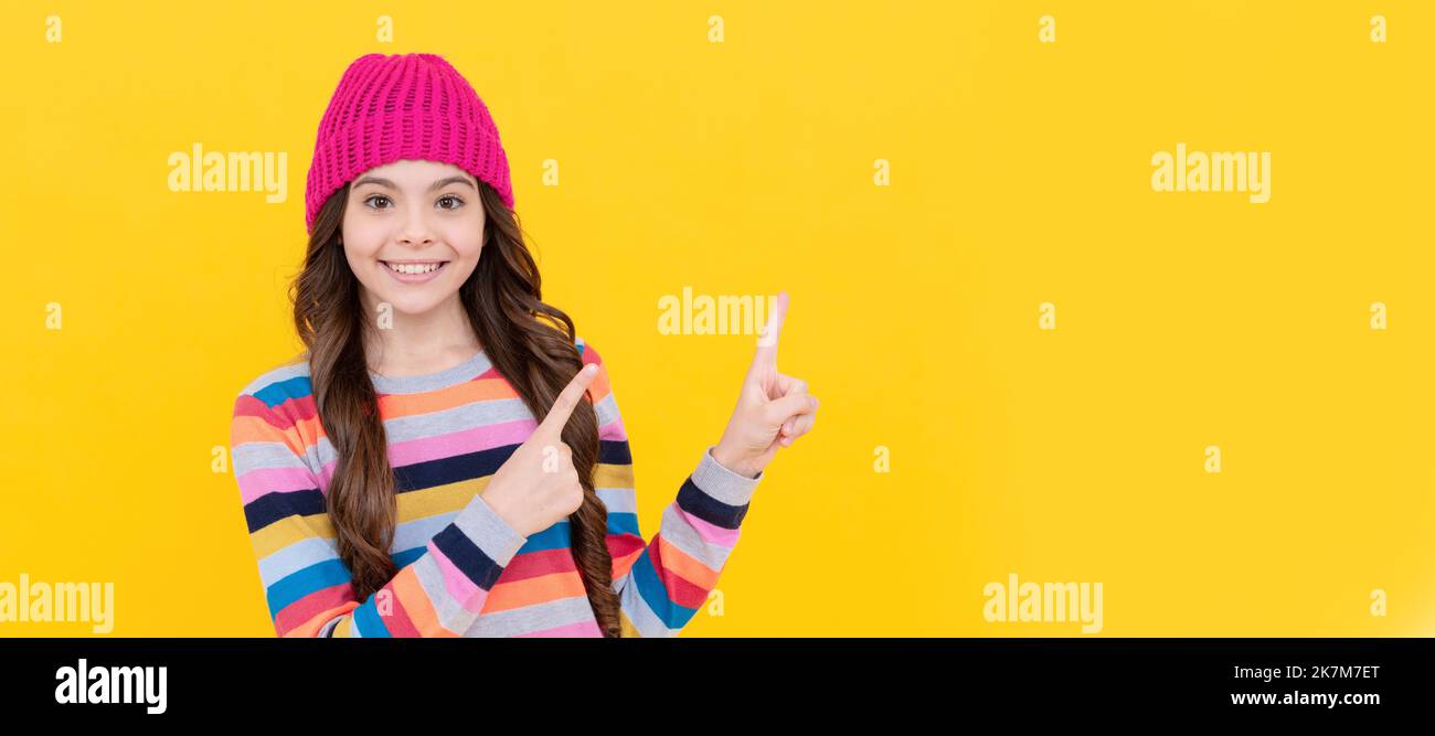 happy teen girl make choice pointing finger on copy space for promotion ...