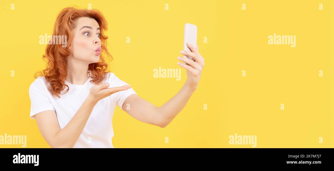 Girl make hand kissing gesture to camera phone yellow background ...