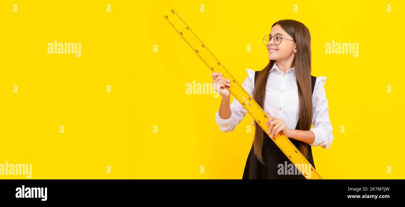 smiling child in school uniform and glasses hold mathematics ruler for ...