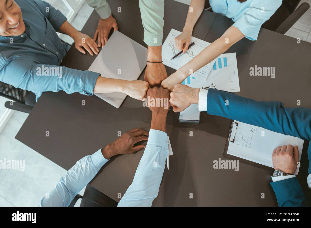 Top view of group multi ethnic coworkers stacked hands together as ...