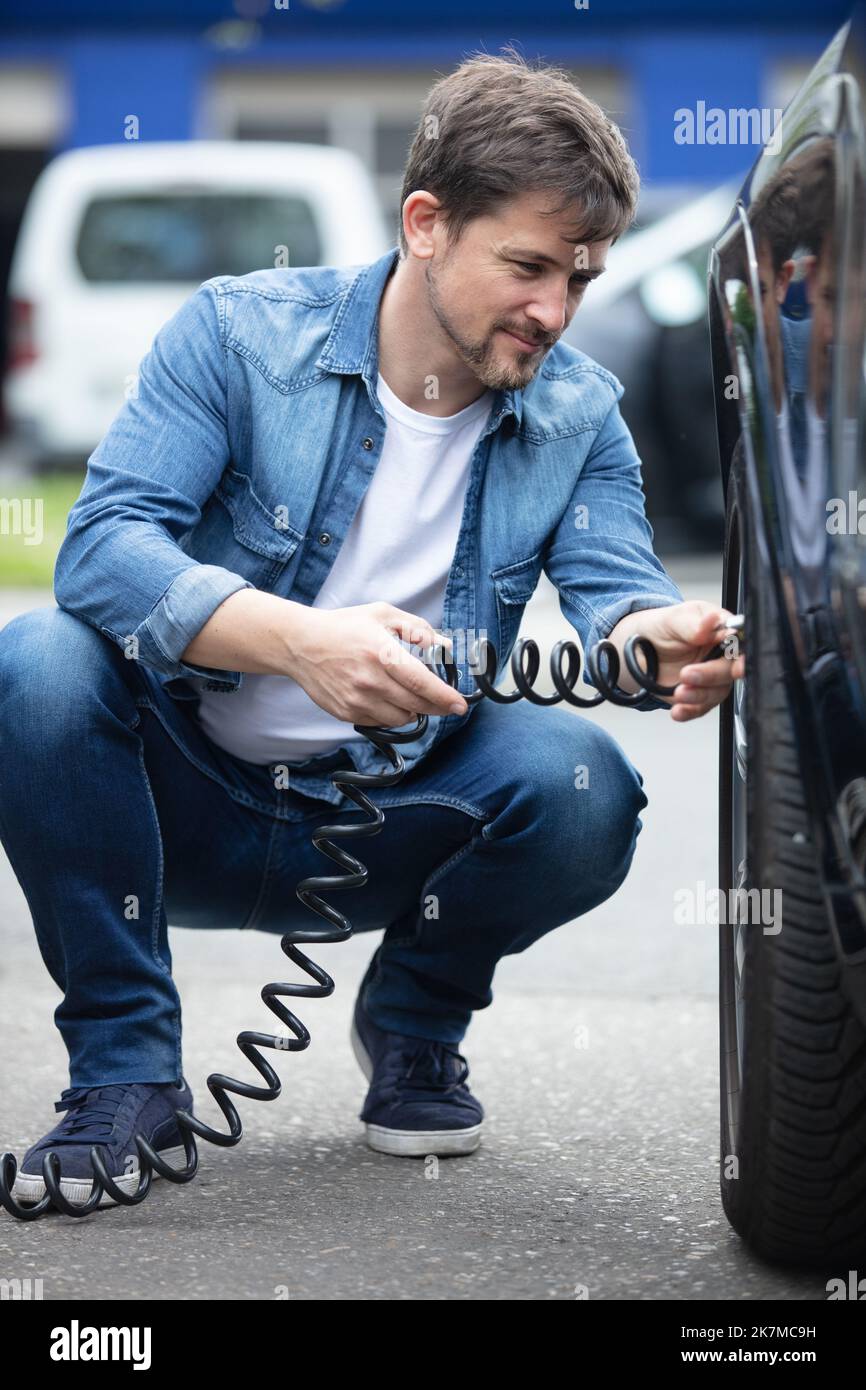 a male inflating cars tyre in station Stock Photo - Alamy
