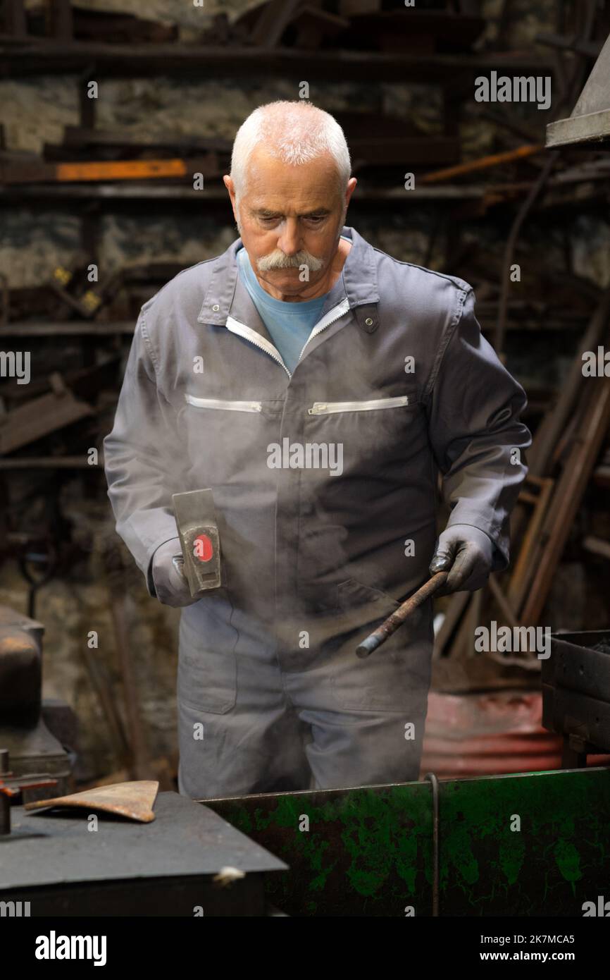 senior factory worker using a hammer Stock Photo - Alamy