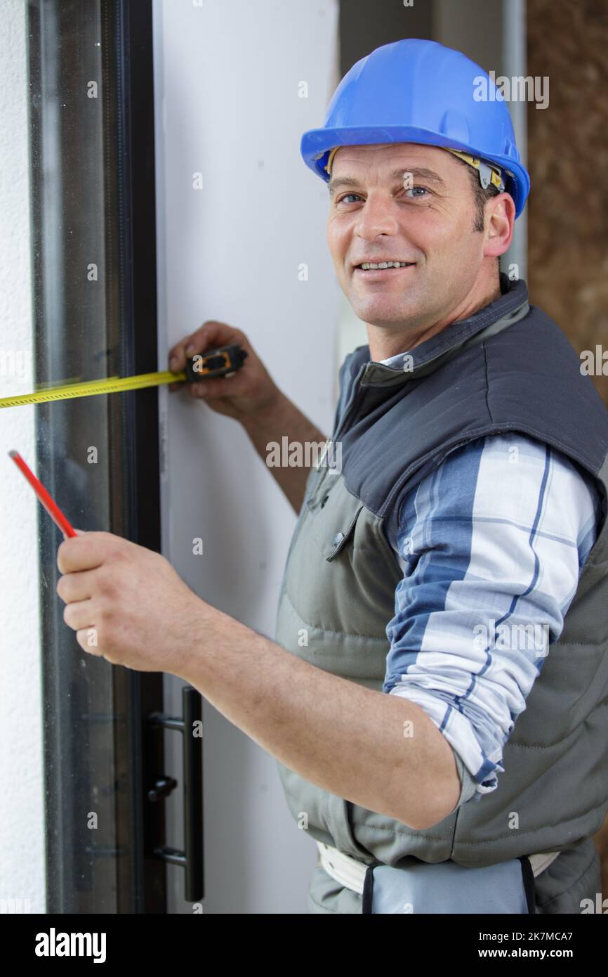 man measuring window at site Stock Photo - Alamy